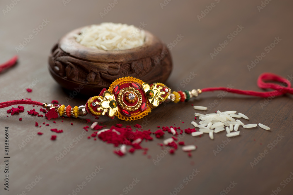 Indian festival: Raksha Bandhan background with an elegant Rakhi, Rice ...