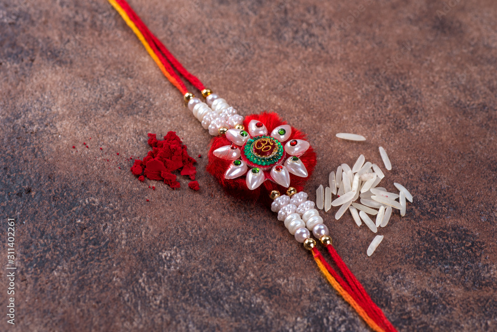 Raksha Bandhan : Rakhi with rice grains and kumkum on stone background ...