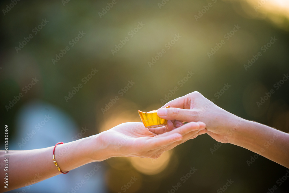 Close up hand holding gold bar for chinese new year sending and ...