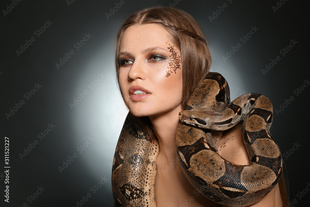 Beautiful woman with boa constrictor on dark background Stock Photo ...