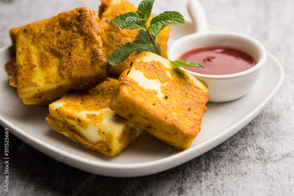 Amritsari Paneer Tikka made using cottage cheese cubes dipped in a ...