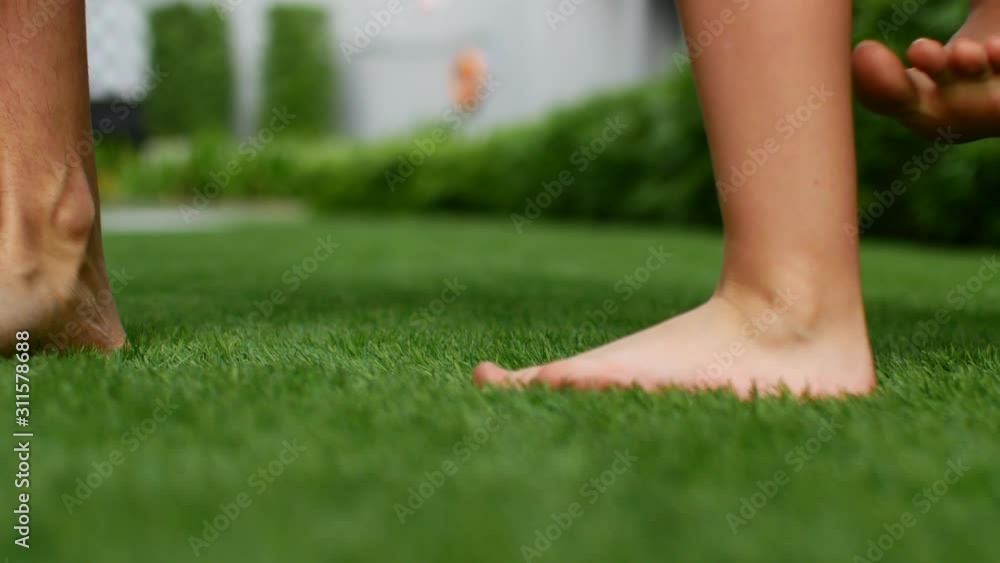 Two barefoot people on the green grass. Step on each other's foot Stock ...