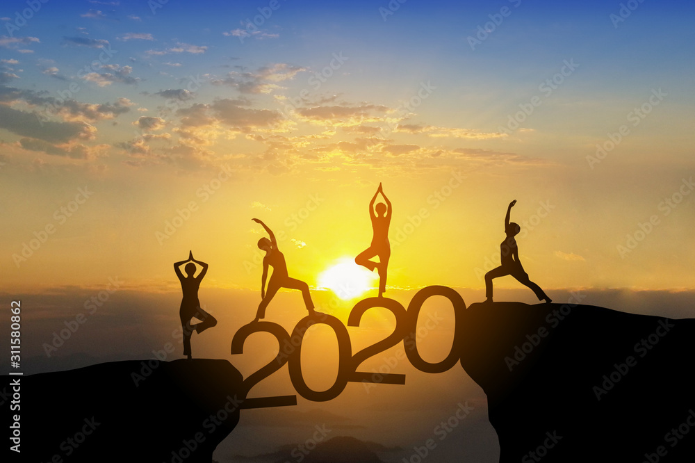 Silhouette image of happy teamwork yoga pose by standing on 2020 text ...