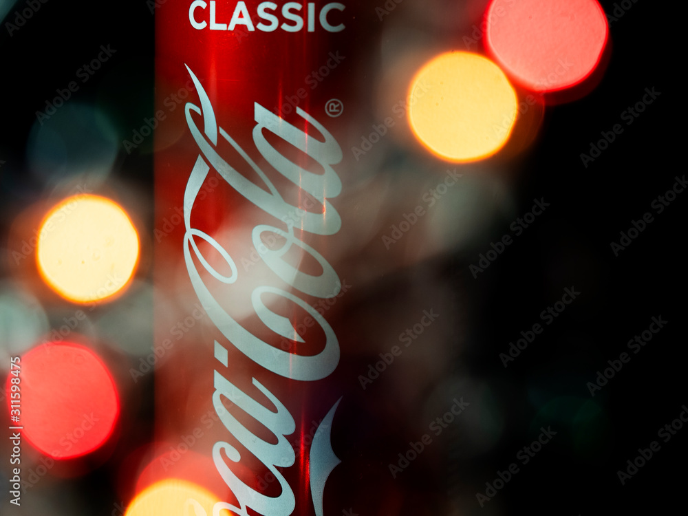 Coca-Cola logo seen on can with blurred lights on foreground Stock ...