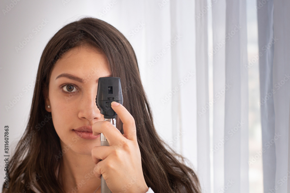 Joven medica examinando ojos en consultorio con equipo de organos para ...