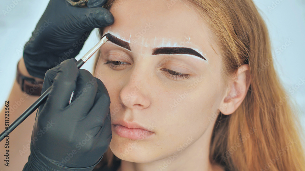 Permanent makeup. Permanent tattooing of eyebrows. Cosmetologist ...