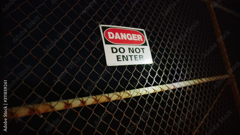 Warning sign on a grid in industrial abandoned building, do not enter ...