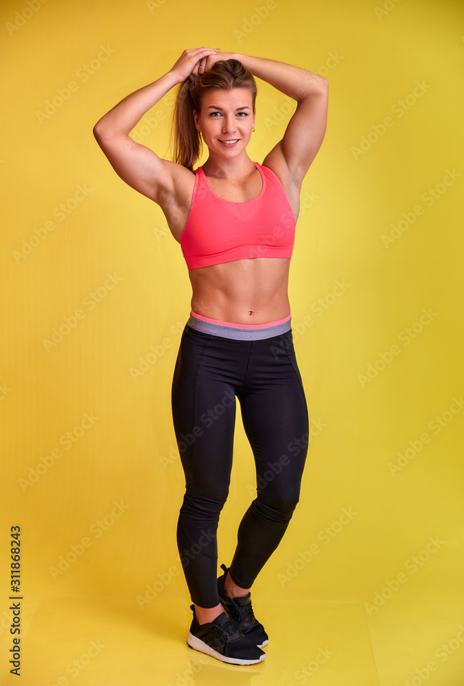 Vertical portrait of a pretty fitness blonde girl with a beautiful ...