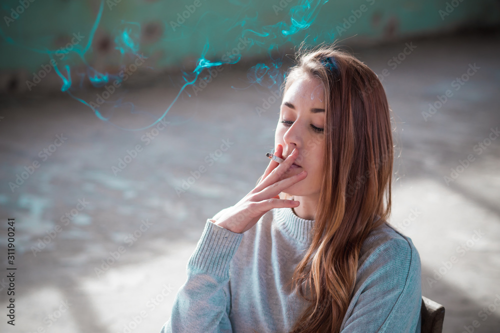 Ginger rebellious girl in gray sweater smoking. Unhealthy habits, stop ...