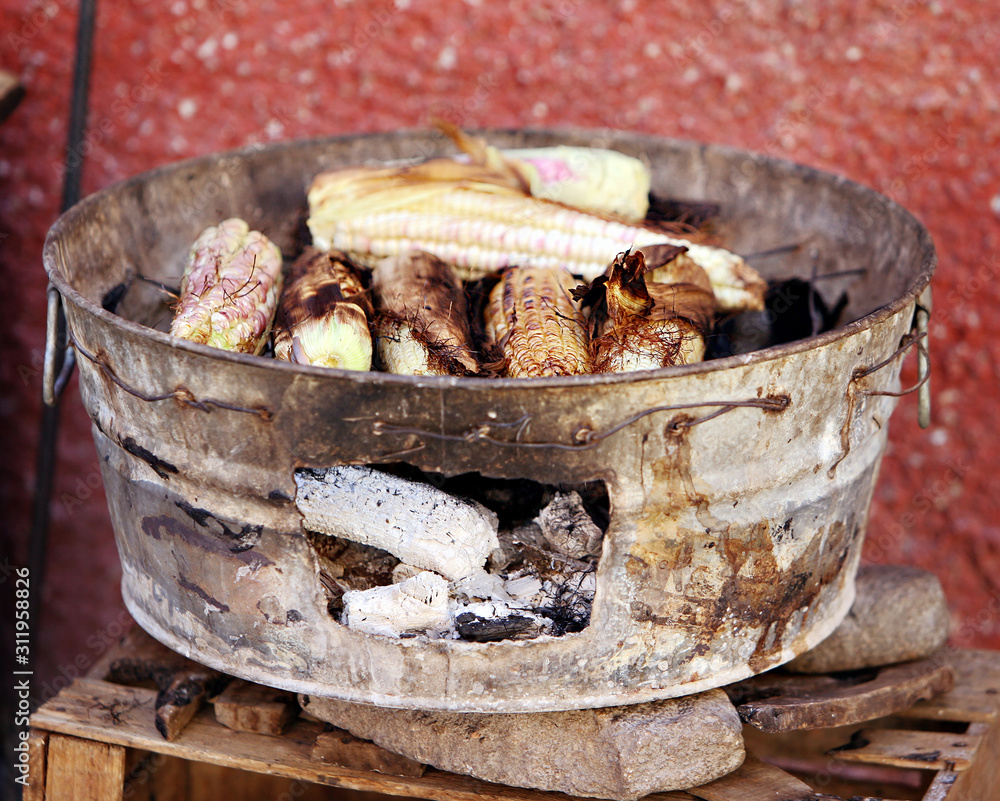 Corn roasting in a wash tub made into a barbecue. Stock Photo | Adobe Stock