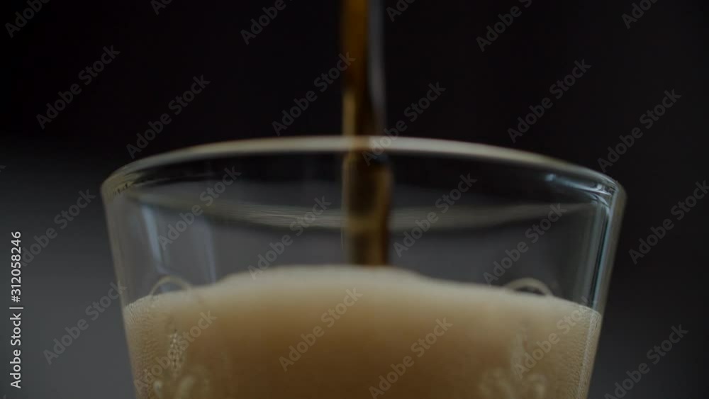 Macro close up of fizzy drink pouring into glass and making bubbles ...