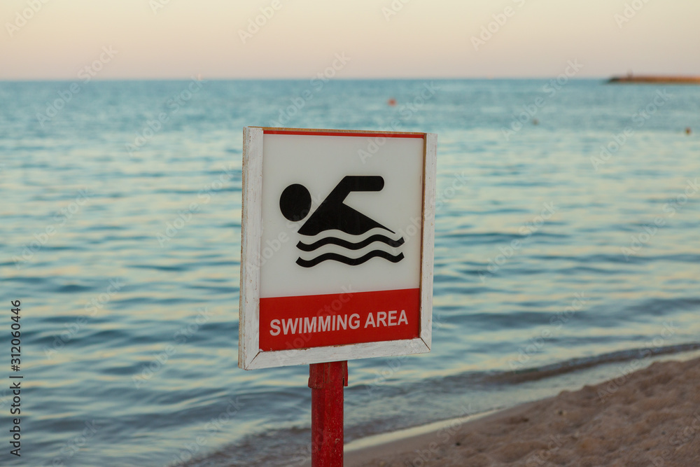 Swimming area sign on the sea beach. Crossed out floating person. Stock ...