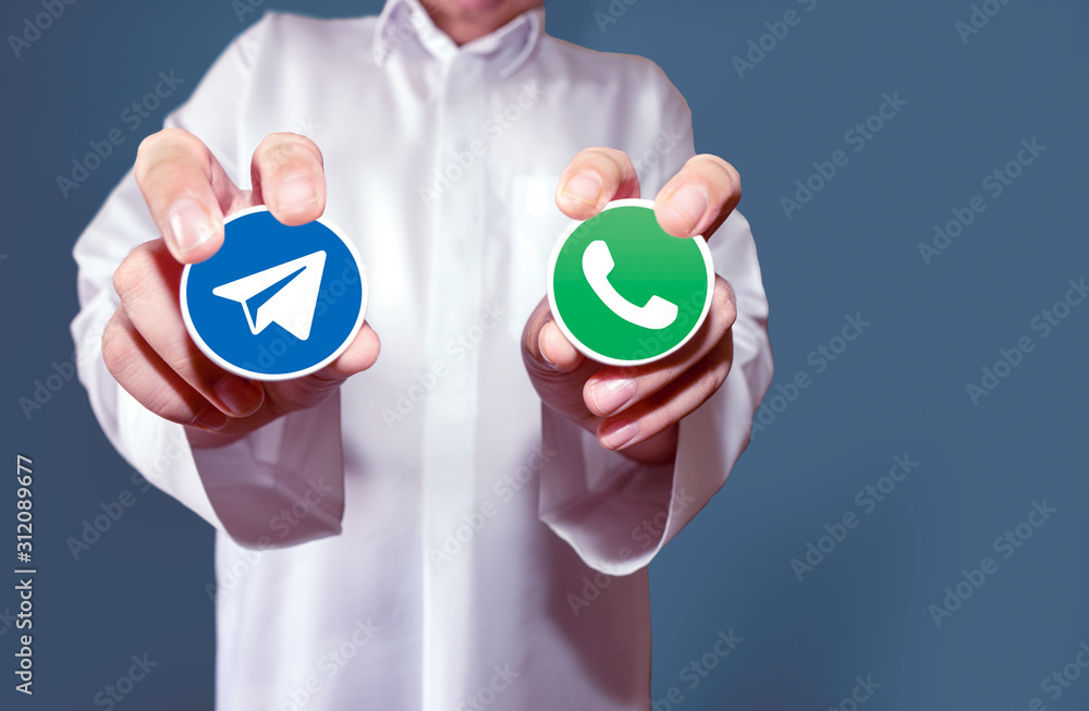 Arab man holding WhatsApp and Telegram Stock Photo | Adobe Stock