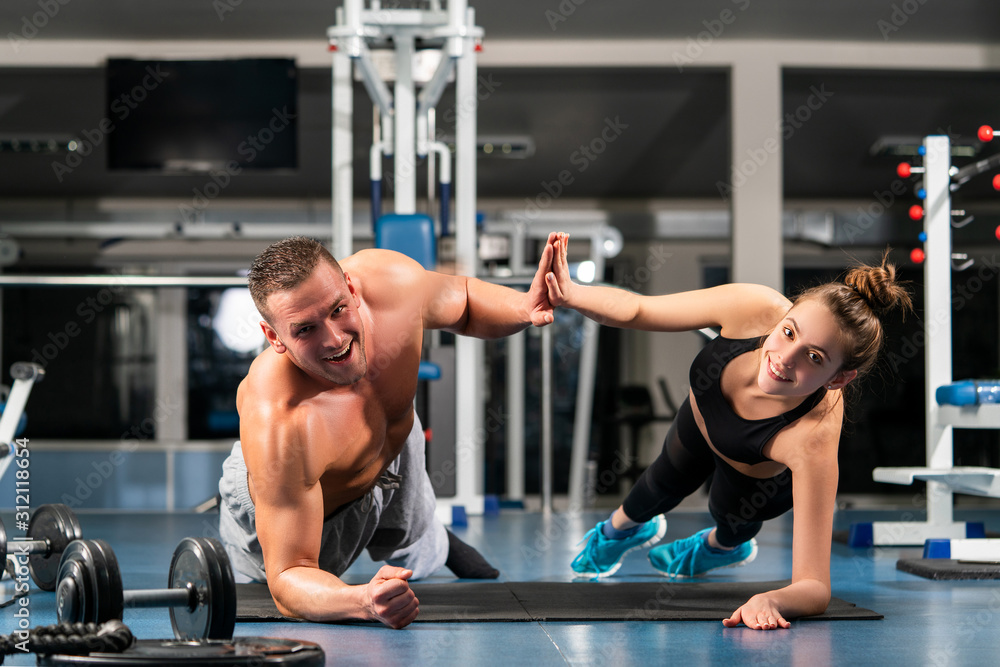 Sporty couple in gym. Attractive sports couple are working out together ...