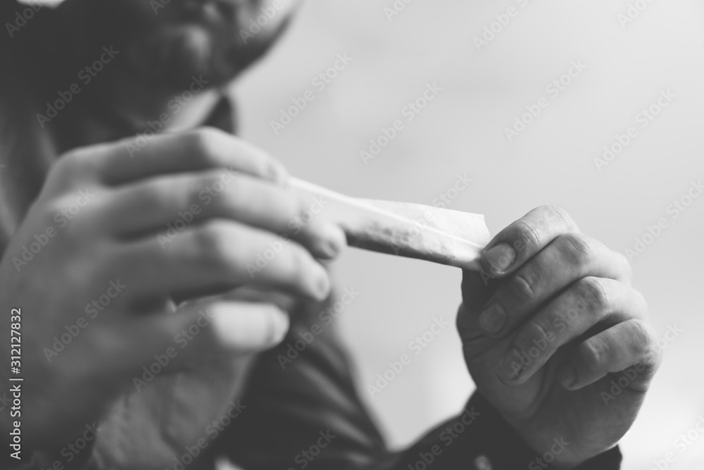 Man rolling a marijuana joint. Man preparing and rolling marijuana ...