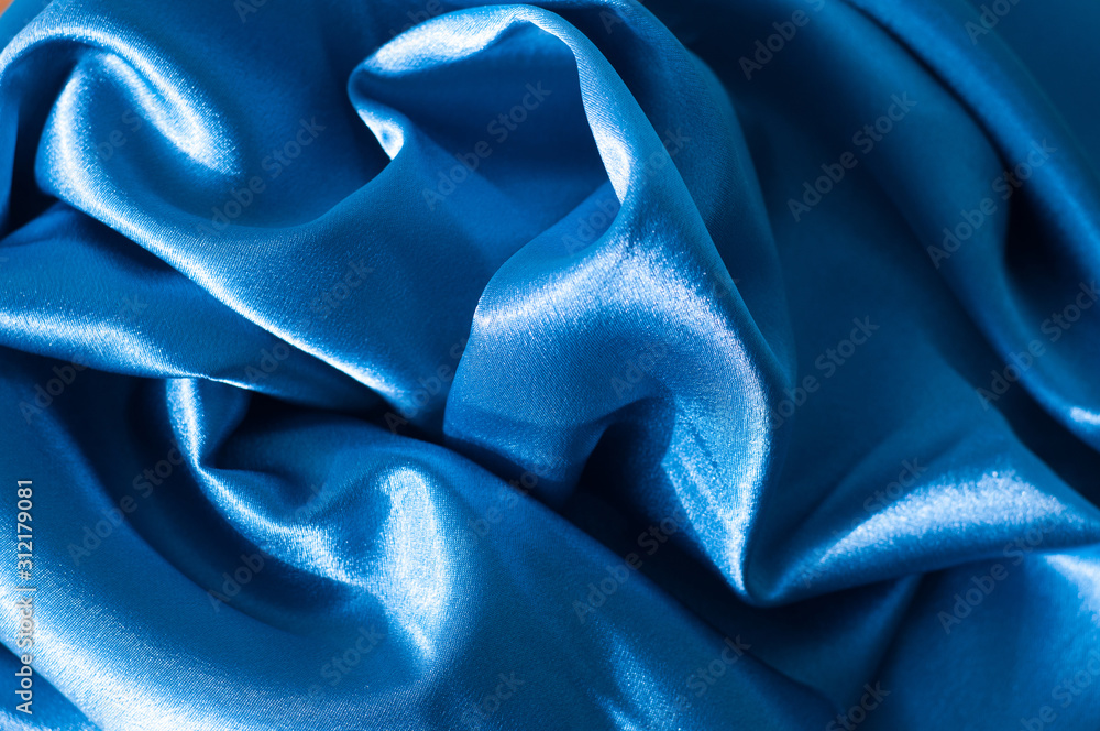 Rich classic blue satin folded fabric texture. Abstract background for ...