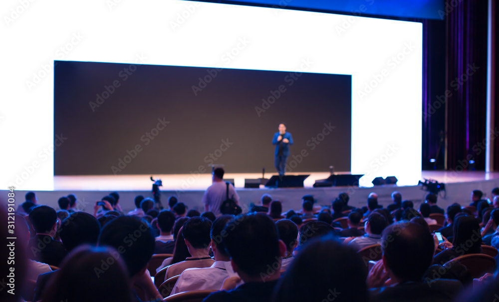 Stockfoto Speaker on the stage with rear view of audience in the ...