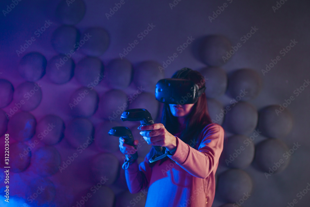 First-person shooter. A woman with glasses and a virtual reality helmet ...