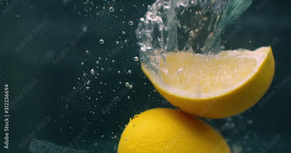 Several lemon fruits fall inside a water tank and disturb water. Three ...