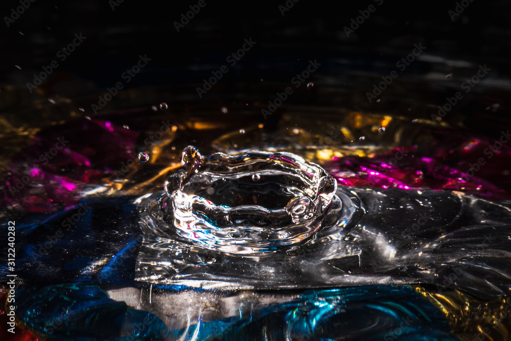water drops splash forming ripples and waves and abstract water columns ...