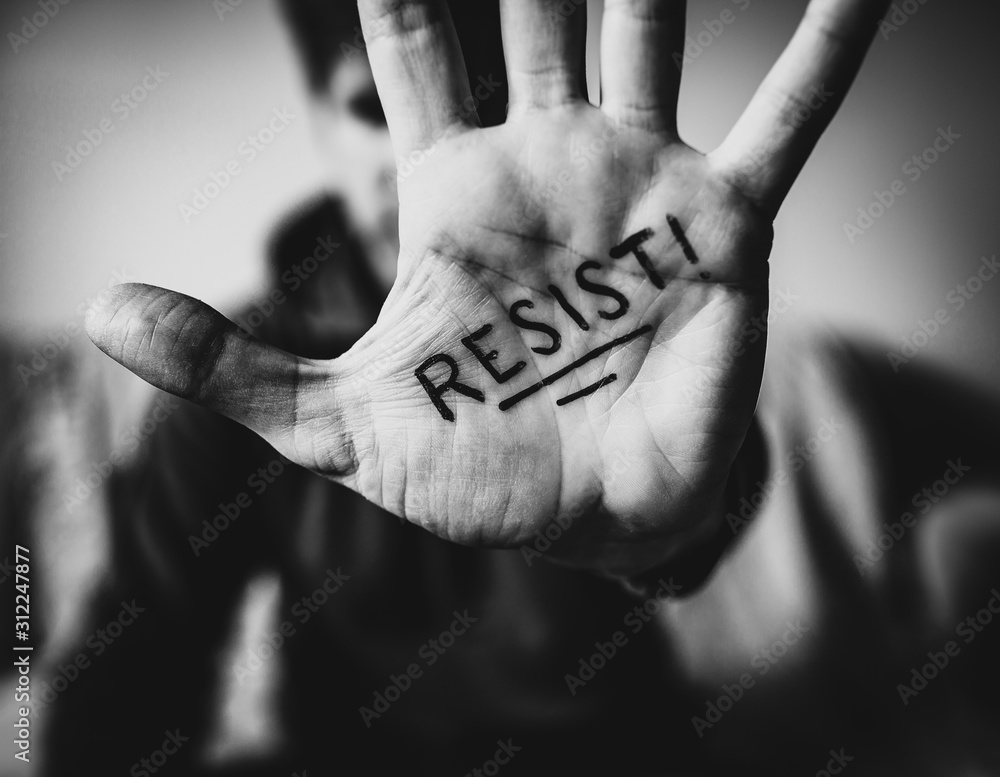 Man holds hand to camera with RESIST written on palm. Stock Photo ...