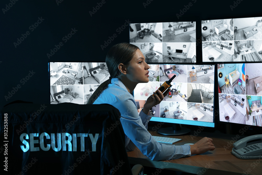 Security guard with portable transmitter monitoring modern CCTV cameras ...