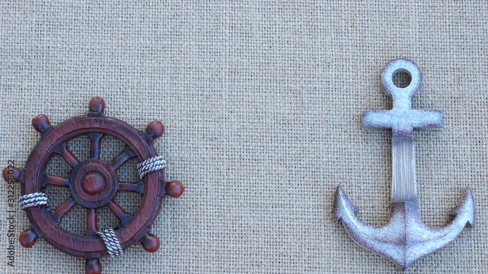 ships wheel and anchor laying on a textured nautical background with ...