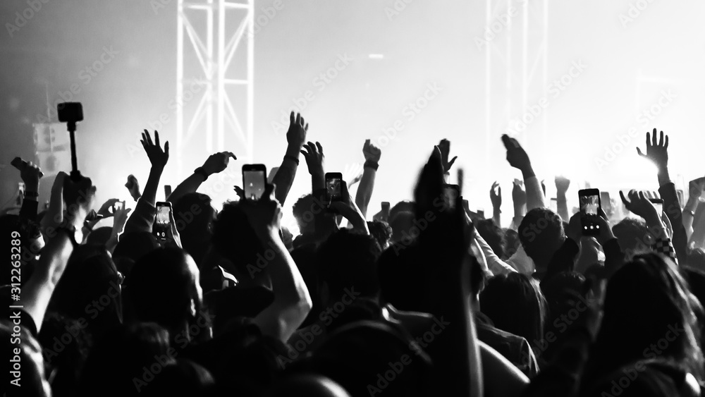 people having fun and dancing with their hands to the sky during a live ...