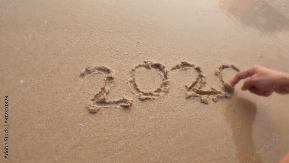 Video Stock Goodbye 2020, lettering on beach was washed off by sea wave ...