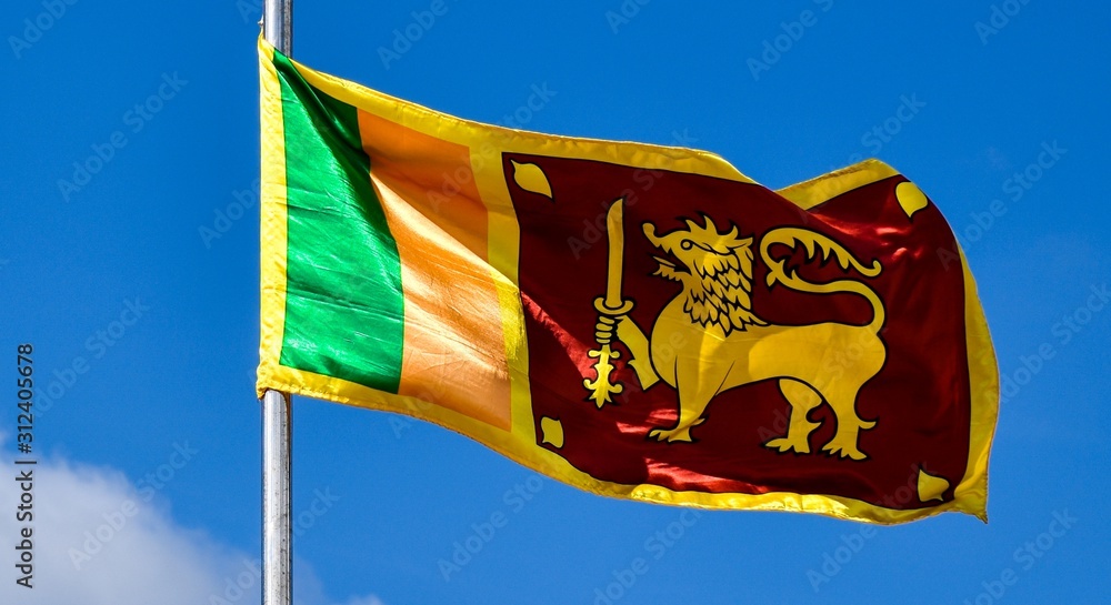 Waving colorful Sri Lankan Lion Flag in cloudy blue sky background ...