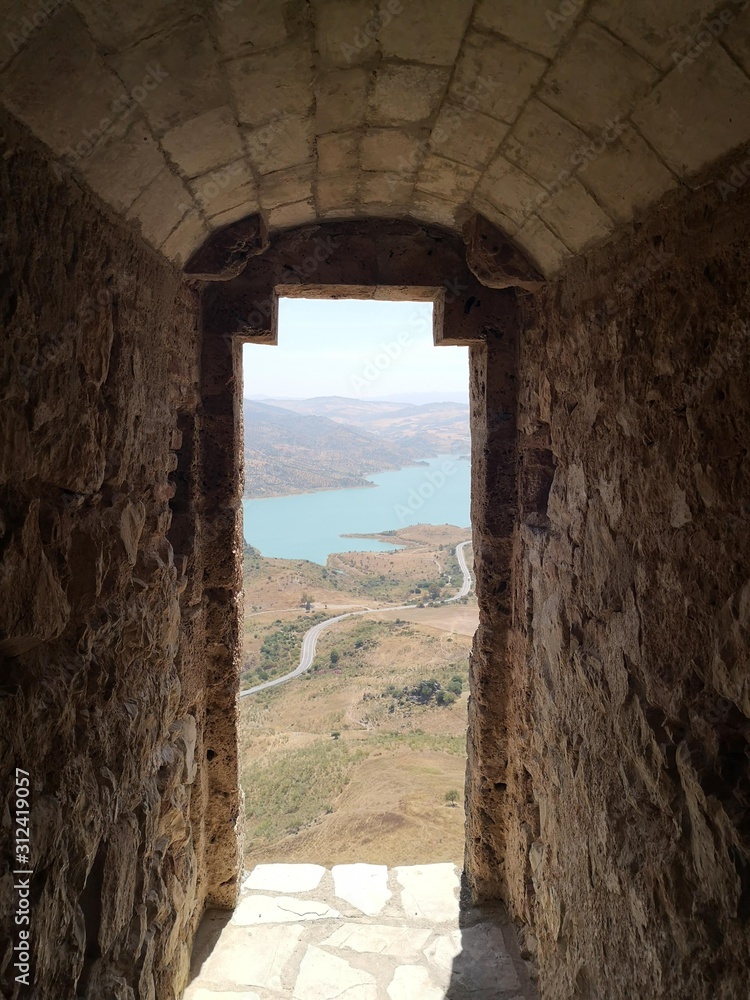 Paisaje de lago, sierra y carretera tomado desde saetera en los muros ...