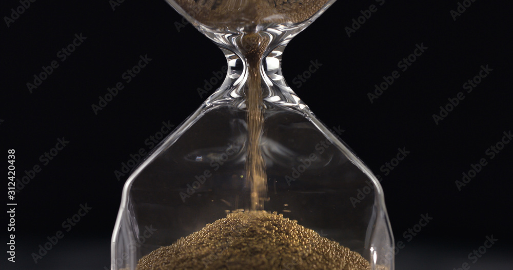 Sand moves through hourglass. Close up of hour glass clock. Old time ...