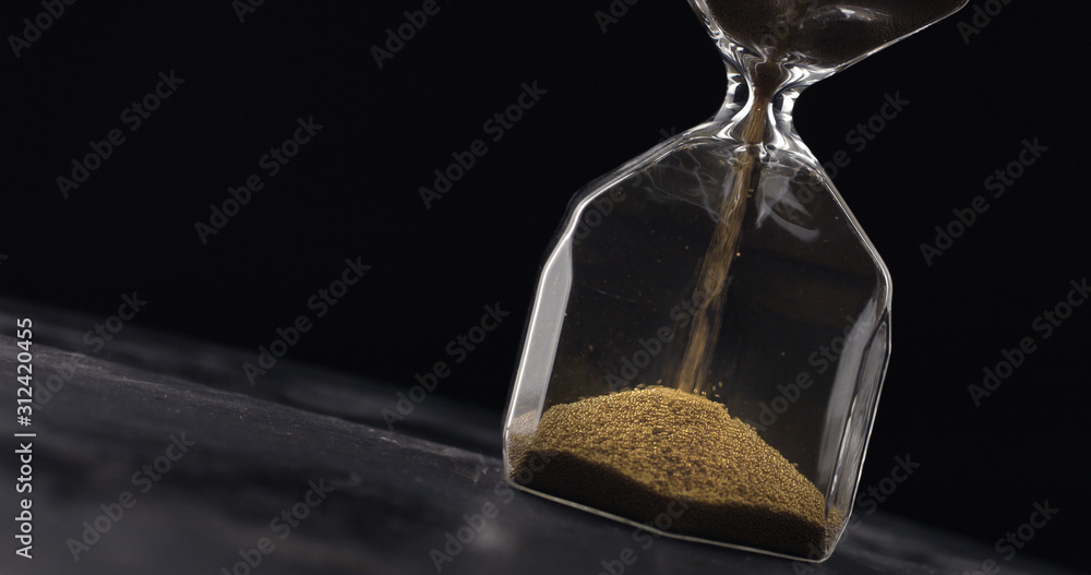 Sand moves through hourglass. Close up of hour glass clock. Old time ...