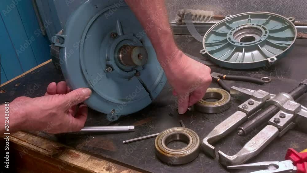 Mechanical service engineer changing bearings on an electric motor at ...