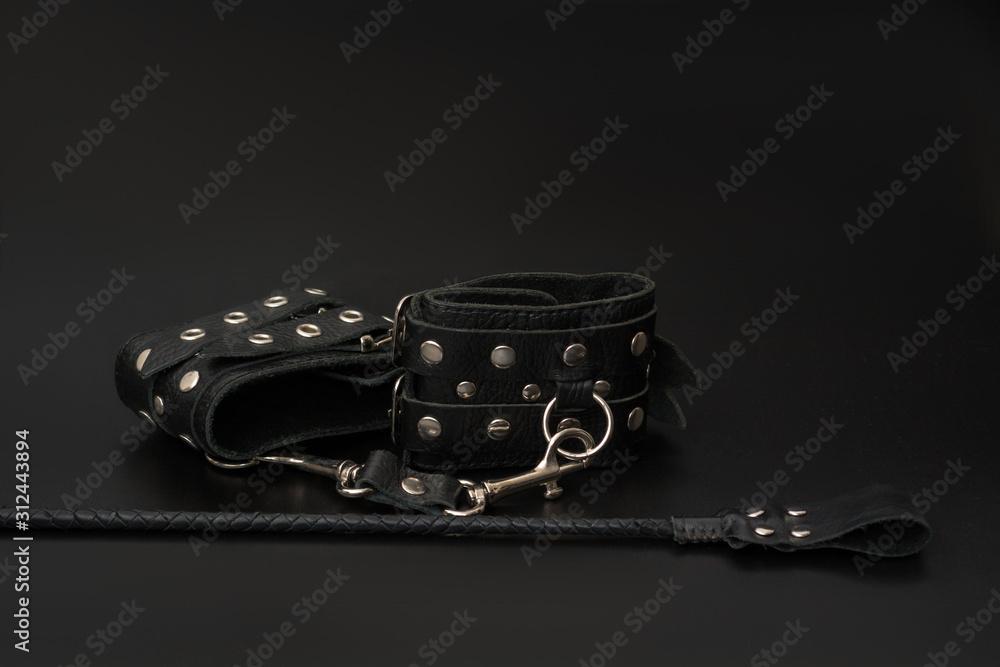 Leather handcuffs and stack for BDSM games on black background Stock ...
