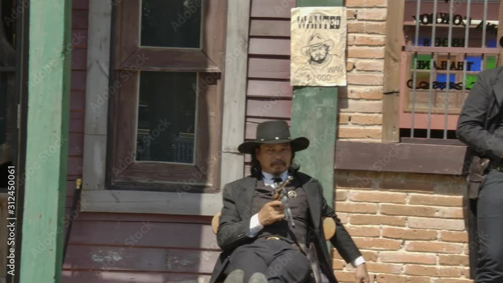 A sheriff sitting outdoor infront of sheriff office while sheriff play ...