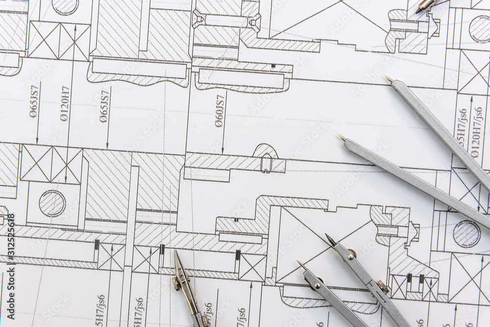 Paper with technical drawings and work tool on table. place of work ...