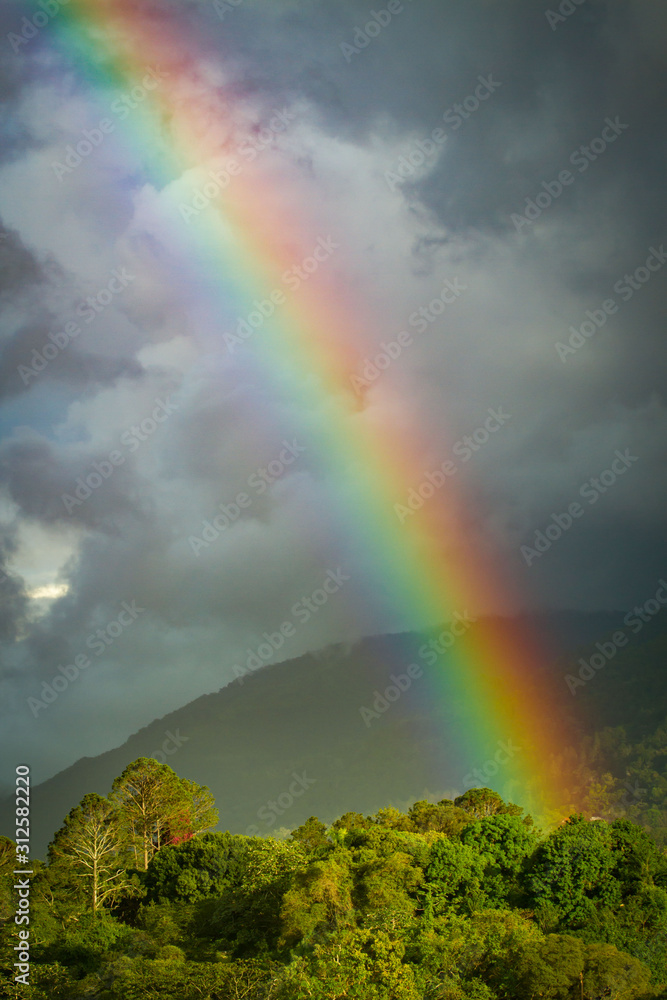 colorful real rainbow and beautiful in turbulent sky landscape ...