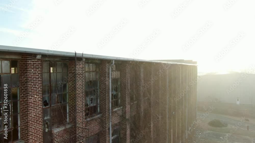 Descending aerial of spooky abandoned former silk manufacturing mill ...
