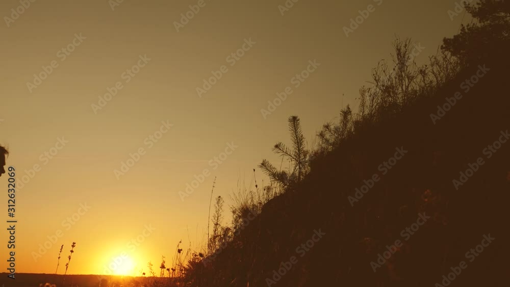 tourists go down from the goy in the sunset, holding hands. male ...
