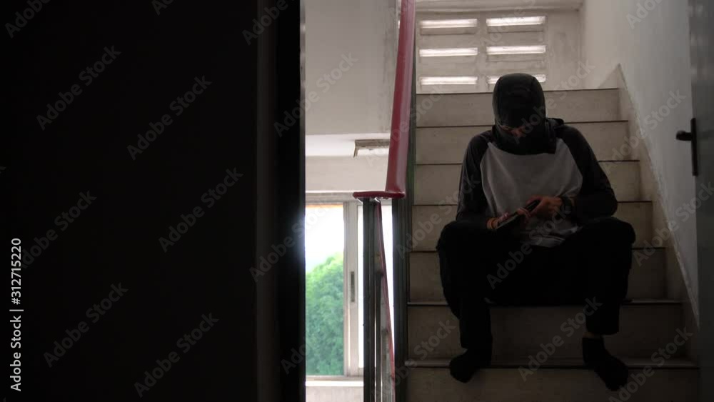 Angry killer in balaclava reading cyber bullying phone message with ...