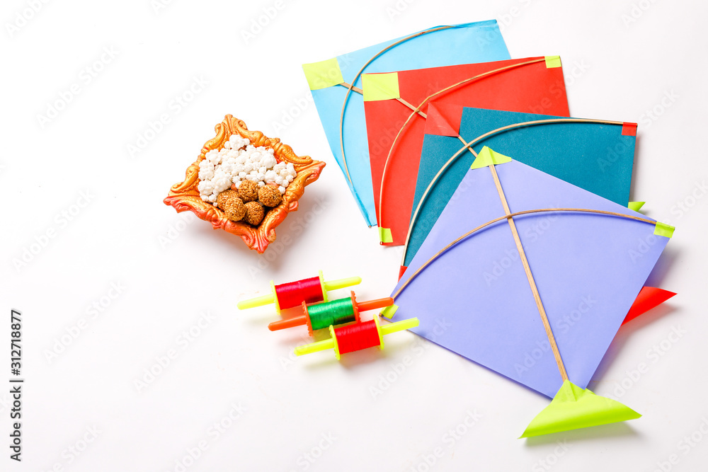 colorful paper kite with sesame seed ball or til ke laddo and tilgul in ...