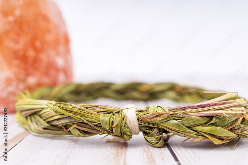 Two ends of a sweetgrass braid tied into a circle with hemp twine on a ...