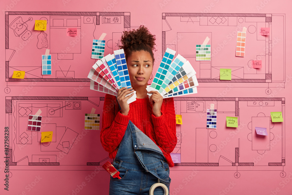 Displeased dark skinned woman holds color palette, looks unhappily ...