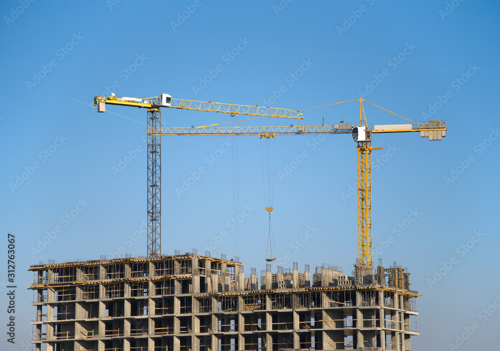 Hydraulic luffing jib tower cranes and workers being poured concrete ...