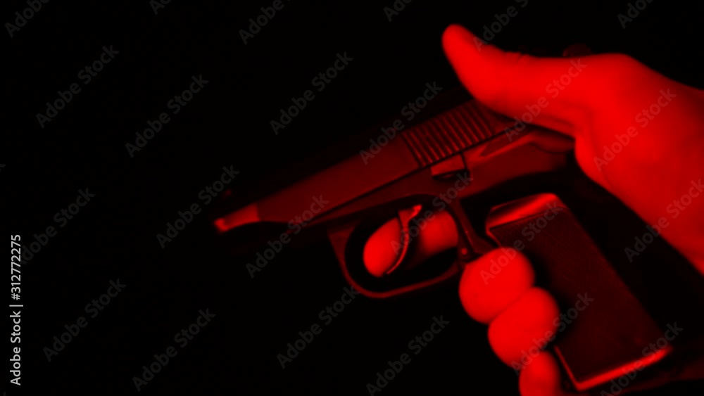 Horror scene of male hand with gun at red glowing light. Serial killer ...