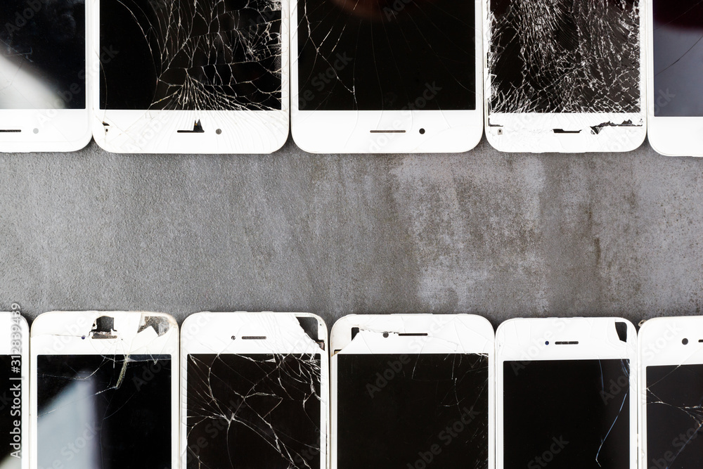 Close up of row cracked/broken screen/glass of mobile phone on gray ...
