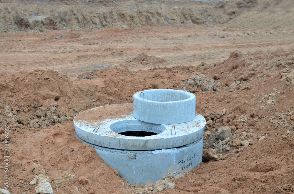 Installation of concrete sewer wells in the ground at the construction ...