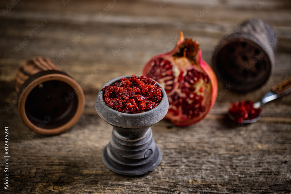 Stone hookah head on old rustic table with fruit flavoured tobacco ...