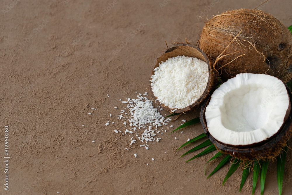 fresh half cut and whole coconuts with coconut flakes on background ...